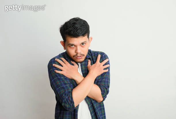 Portrait of asian guy shivering, trembling and feeling cold, hugging ...