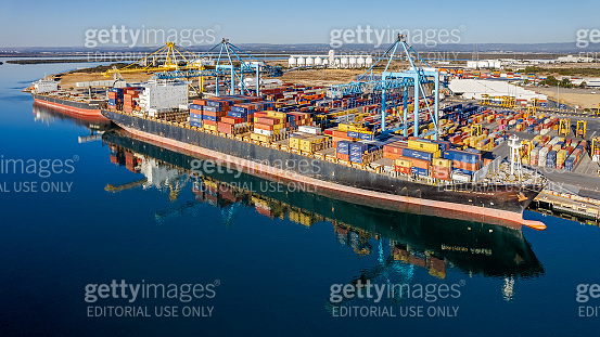 Aerial view large container ship loading/unloading at Port Adelaide dwarfing grain bulk carrier ...