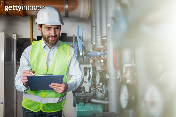 Oil and gas production manager or supervisor with tablet checking gas ...