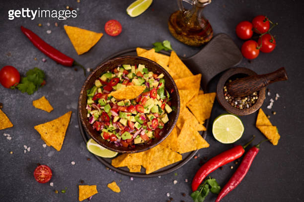 traditional salsa dip snack in wooden bowl and corn nacho chips on a ...