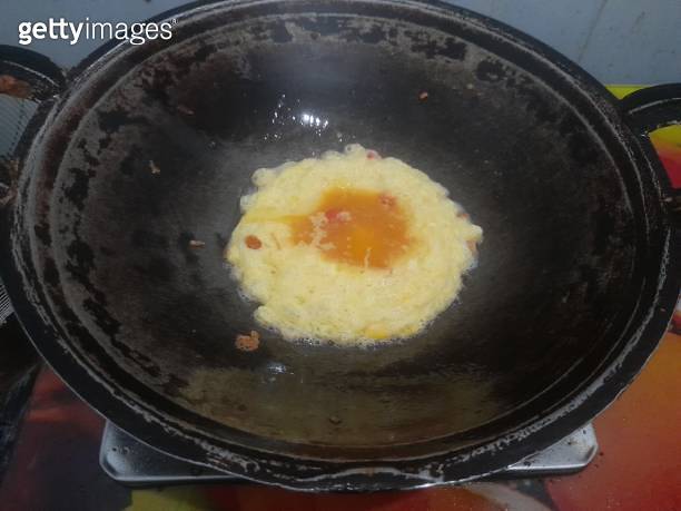 the process of making fried eggs (telur ceplok) in a frying pan seen ...