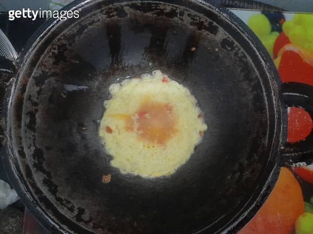 the process of making fried eggs (telur ceplok) in a frying pan seen ...