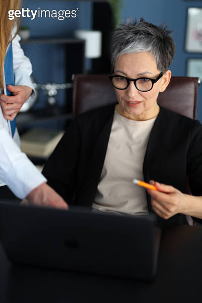 A businesswoman works in her office, using a computer confidently ...