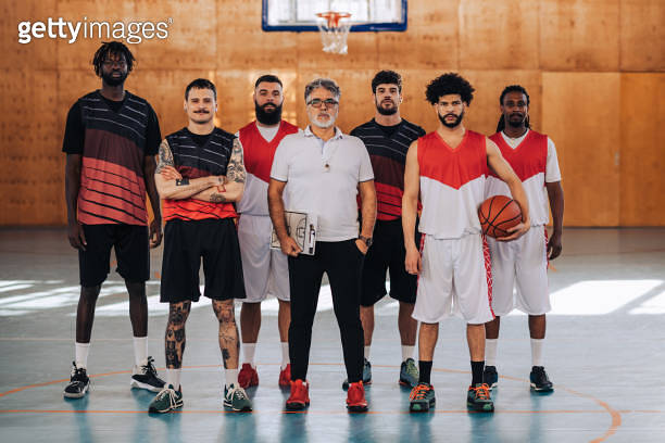 A multicultural basketball team with their coach on training ...