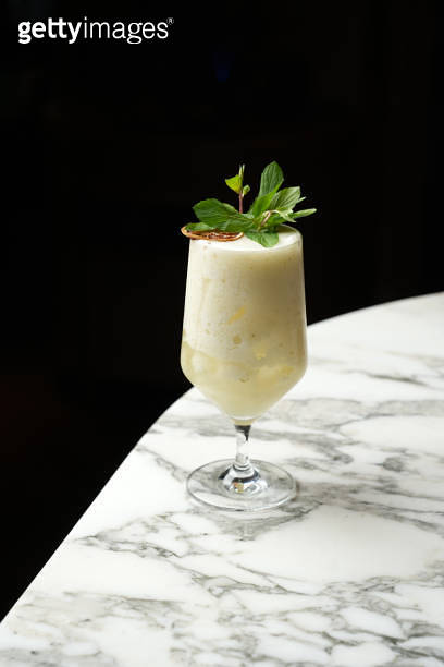 Pina colada cocktail with dry lemon slice and peppermint leaves ...