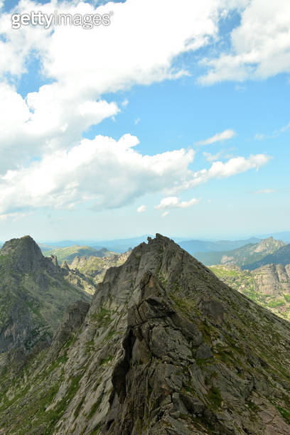 A narrow ridge of high rock with steep peaks in a chain of picturesque ...