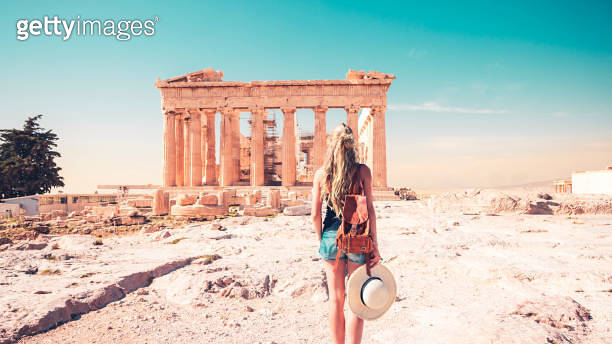 Rear view of female tourist looking at old greek temple ruins-Athens ...