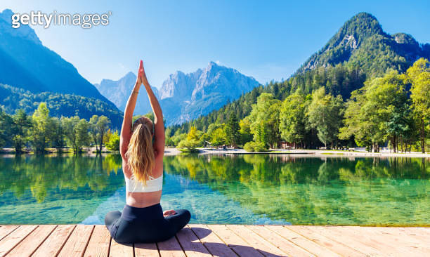 Woman doing yoga in beautiful nature with lake and forest- relax, zen ...