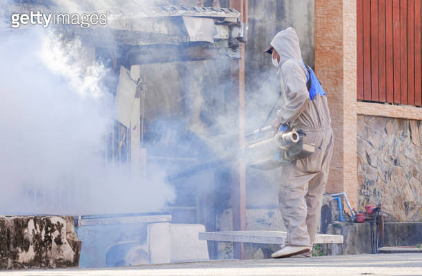 Outdoors healthcare worker using fogging machine to spraying chemical ...