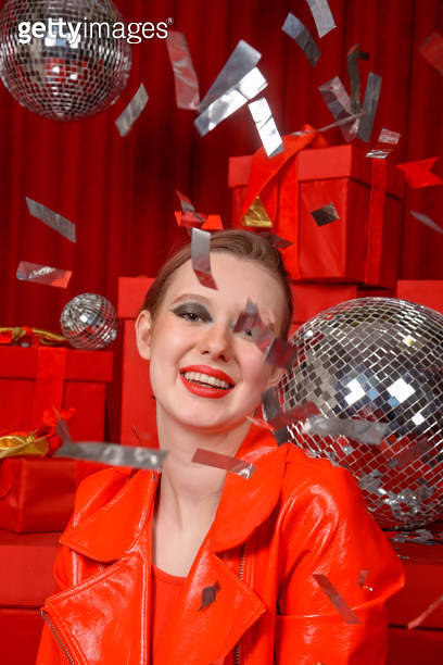 Beautiful girl in shiny red patent leather jacket at a red festive ...