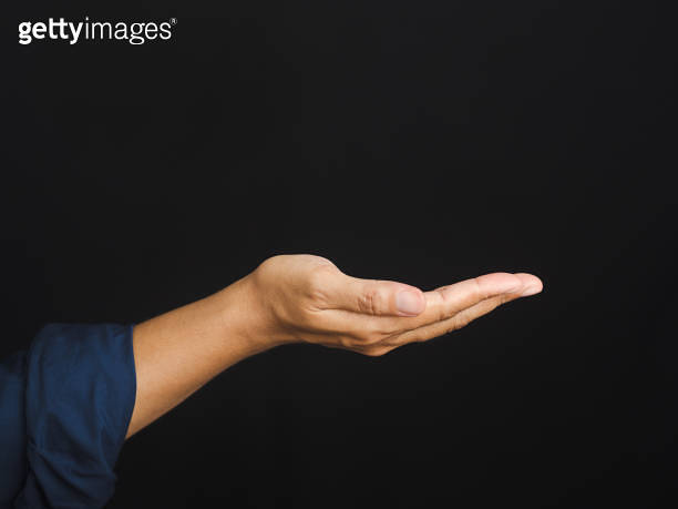 Close-up of an empty open hand palm up. Side view isolated on a black ...