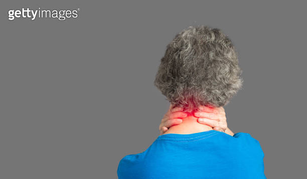 Back view of a senior woman suffering neck pain and neck tilt while ...