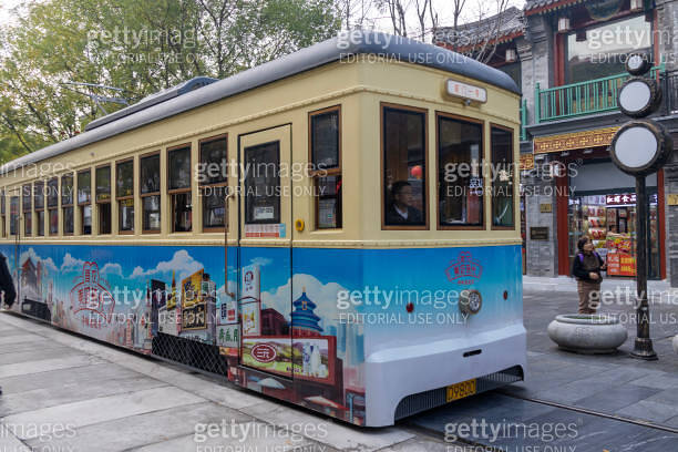 Historical tram passes by the Qianmen pedestrian street in Beijing ...