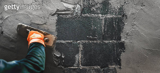 person is using a trowel to spread a substance on a wall 이미지 ...