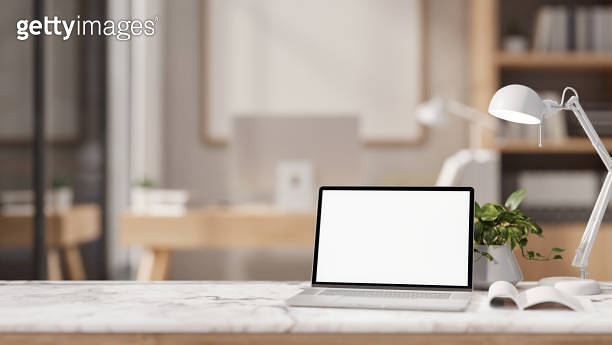 The table showcases a white-screen laptop computer in a contemporary ...