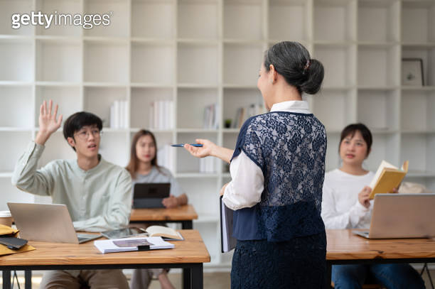 A back view image of a teacher professor giving a lecture to her ...