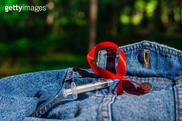 Red ribbon,syringe,needle,denim jacket. symbol HIV,AIDS cancer ...