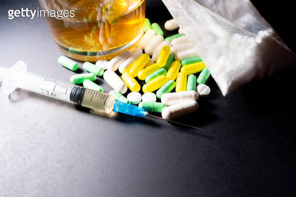 Hard drugs and alcohol on dark gray table. Alcohol pills syringe ...