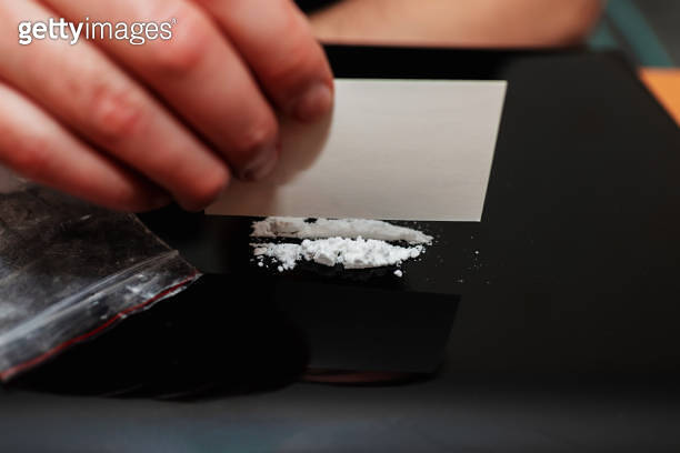 Addict makes track of cocaine.addicted drug user to make lines of white ...
