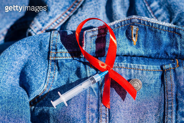 Red ribbon,syringe,needle,denim jacket. symbol HIV,AIDS cancer ...
