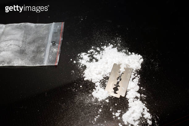 Razor Blade on drug powder,cocaine bag on reflection black background ...