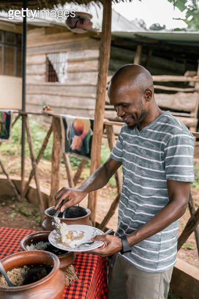 African man preparing ugali traditional dish on a rural kitchen 이미지 ...