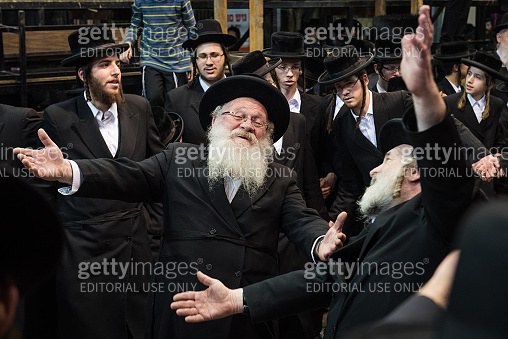 Elderly, bearded Orthodox Jewish men dance and sing during a ...