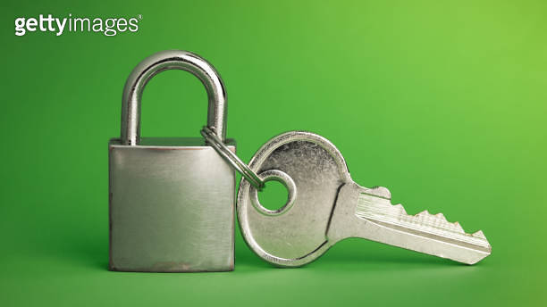 Simple lock and key. Small worn padlock with over large shiny key ...