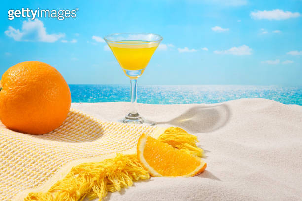 Front view of fresh oranges, a cocktail and a tablecloth placed on ...