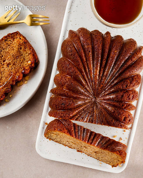 Sliced pound cake on a cutting board on a trendy color background. Step ...
