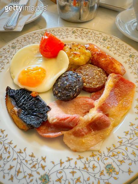 Full Irish cooked breakfast of bacon sausage fried egg tomato mushroom ...