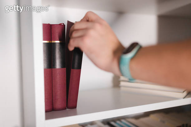 Close-up of a human hand taking a book from the bookshelf 이미지 ...