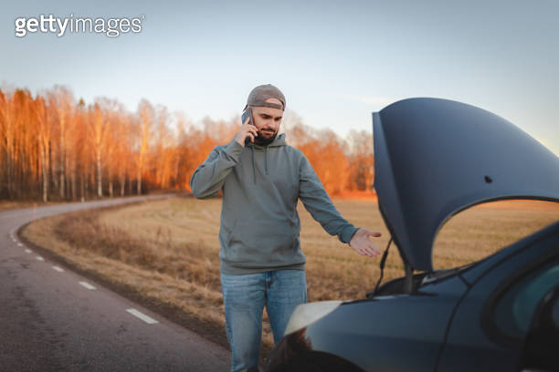 Young man calling for help while stranded on the road (2075666079) - 게티 ...