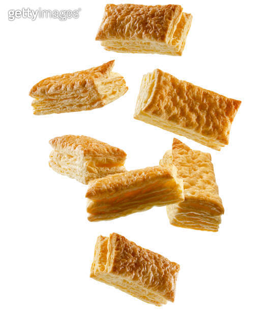 Rectangular puff pastry pies fall in space. Volumetric back light ...
