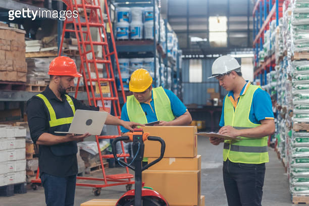 Warehouse worker teamwork diversity men using laptop computer logistics ...