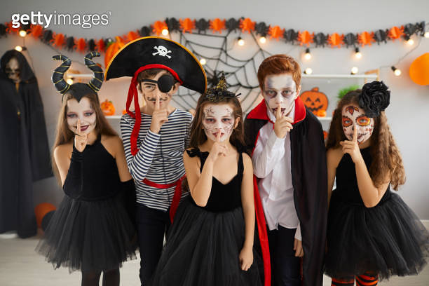 Kids in Halloween costumes doing finger on lip gesture to make you keep ...