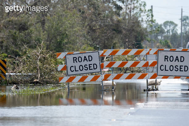 Hurricane flooded street with road closed signs blocking driving of ...