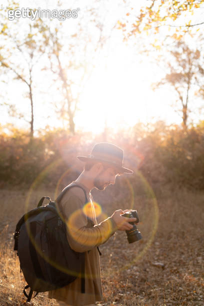 Arabic photographer with camera photographing nature in forest at ...