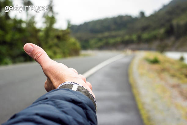 Hitchhiker thumbing a ride outdoors on road. 이미지 (2149157715) - 게티이미지뱅크