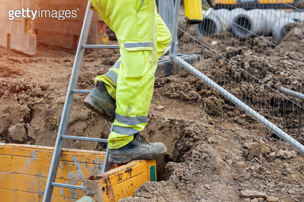 Builder using ladder to get out of safety trench box (2151430517) - 게티이미지뱅크