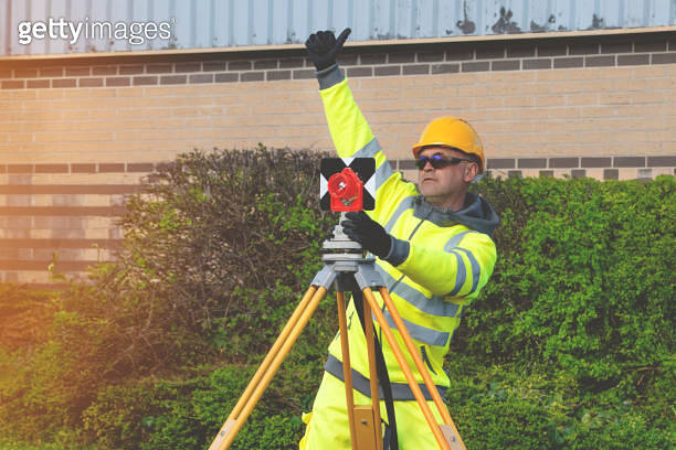 Professional Site engineer giving OK sign after installing backsight ...