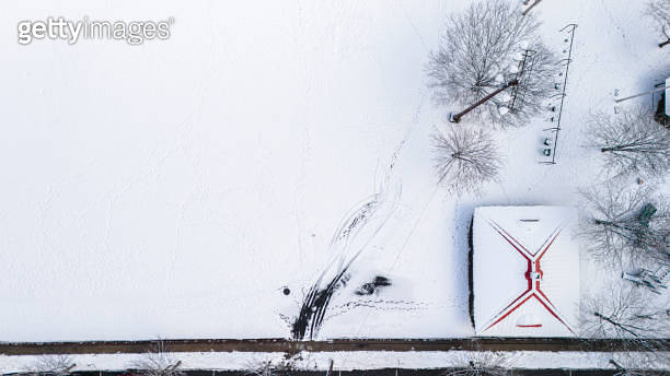 Snow footprints run along a built structure on a snow-covered stadium ...