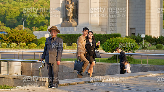 Pyongyang residents stroll through the square near the Arc de Triomphe ...