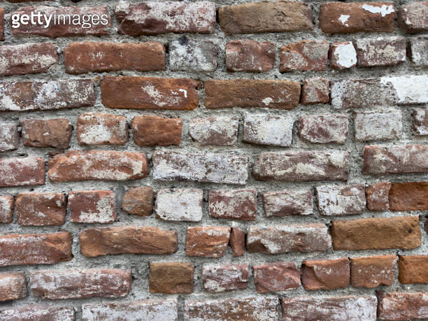 Old unplastered wall. Wall built with red bricks. Reinforced with ...