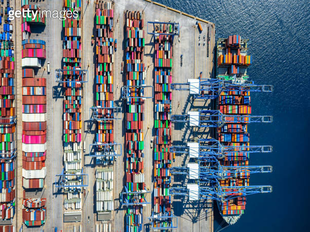 A industrial container cargo ship terminal with unloading activity ...