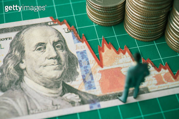 Businessman looking at US dollar banknote tear off as falling down ...