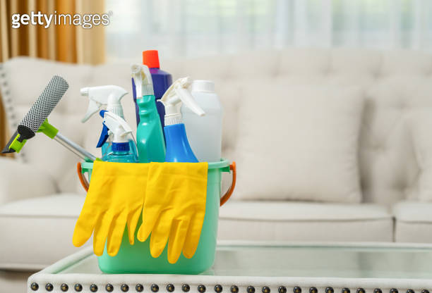 Set of cleaning supplies on the table in room, Bucket with cleaning ...
