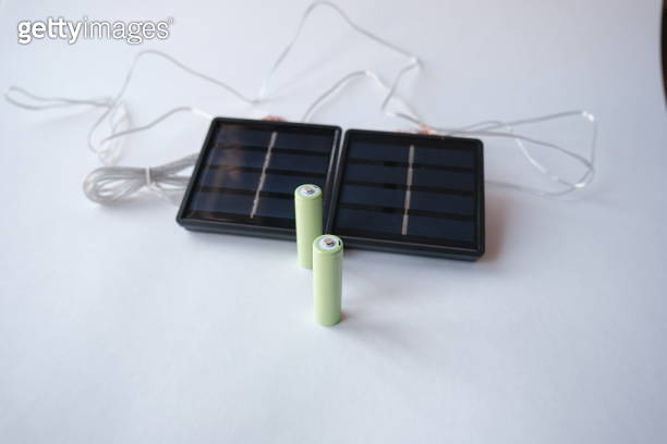 Rechargeable AA batteries. mini solar panel on the background. AA ...