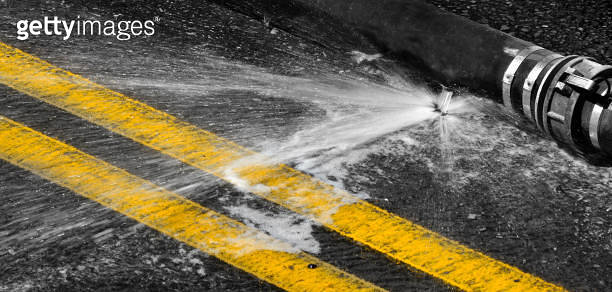 Fire Hose Leaking on Pavement of Road with Double Yellow Lines ...