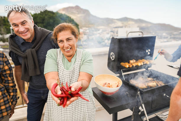 Happy senior people doing barbecue at home's rooftop - Multiracial ...